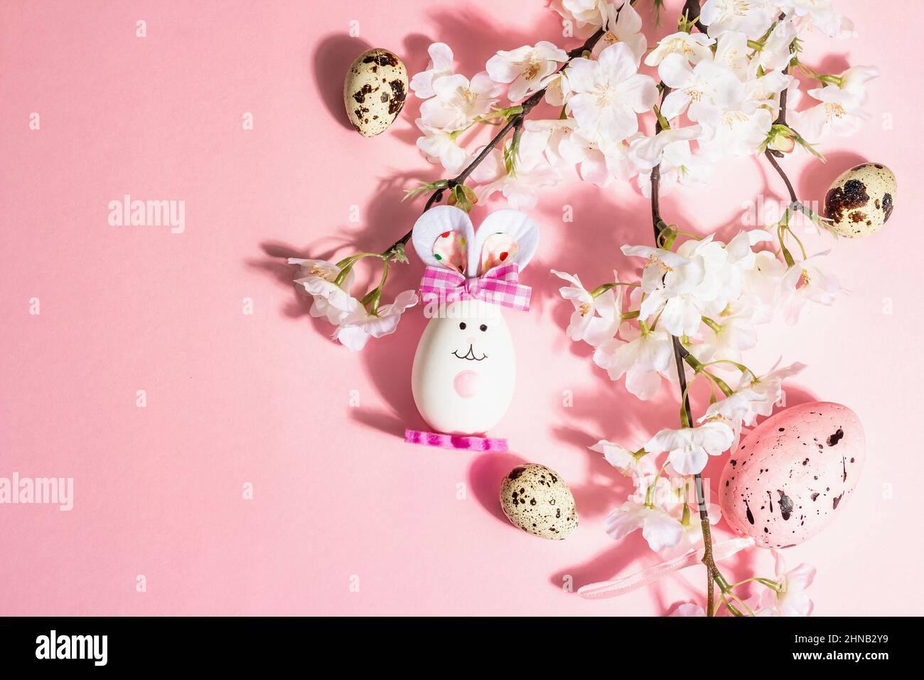 Happy Easter pink background with blooming cherry, quail eggs and cute ...