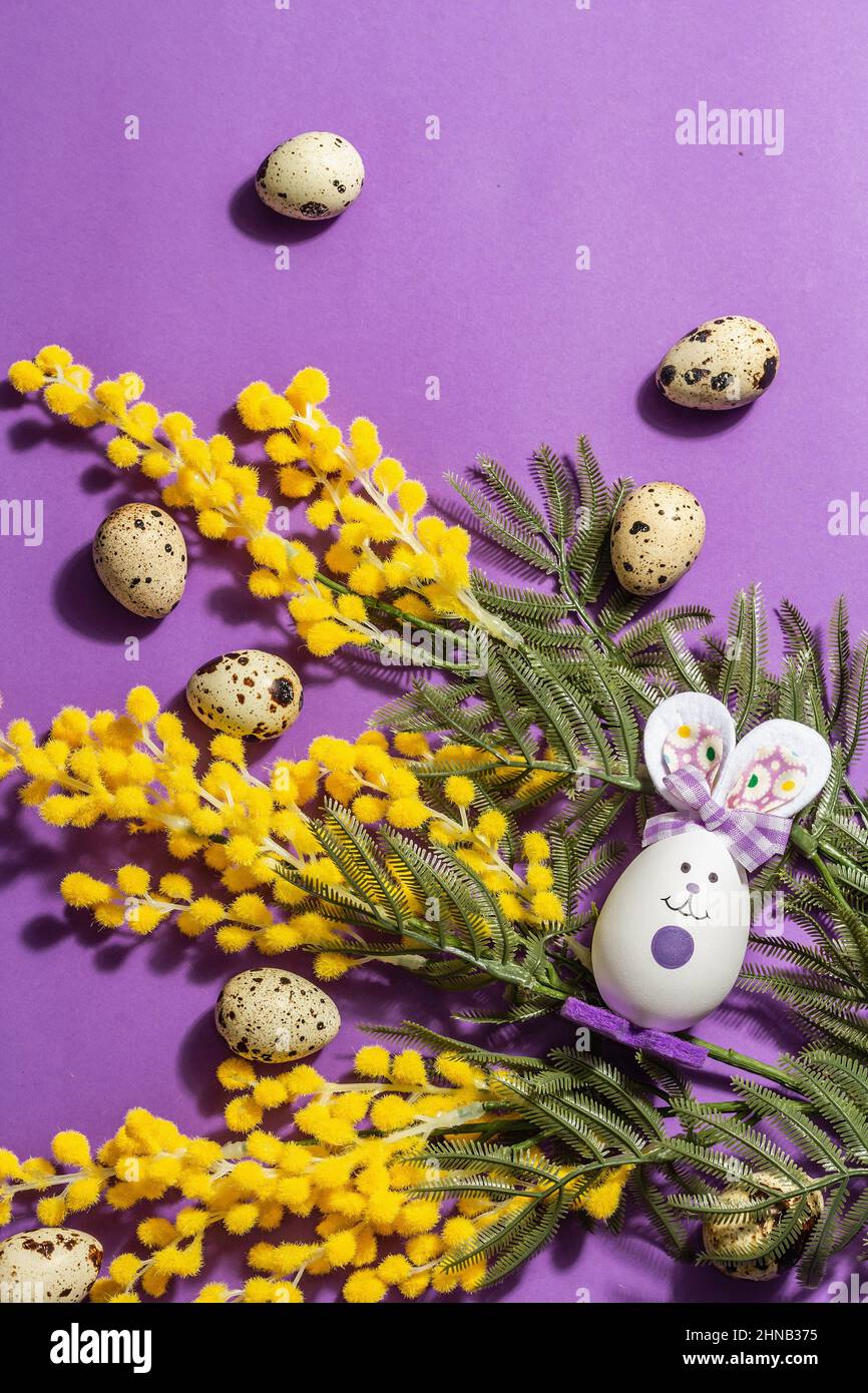 Spring composition with flowers, pastel eggs and cute rabbit on purple ...