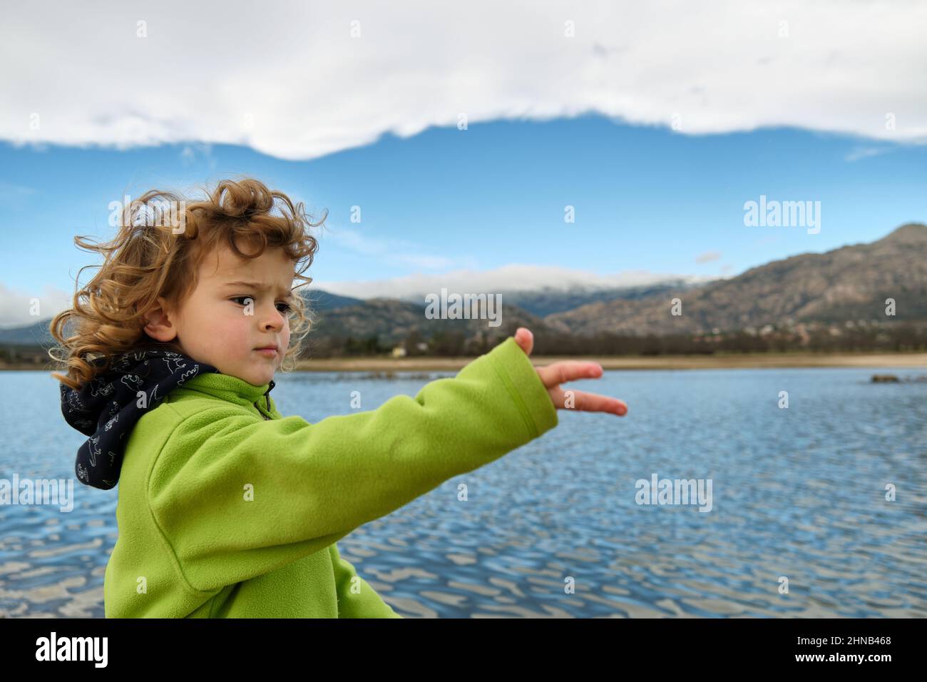 Portrait of a child playing at throwing stones into the water Stock ...