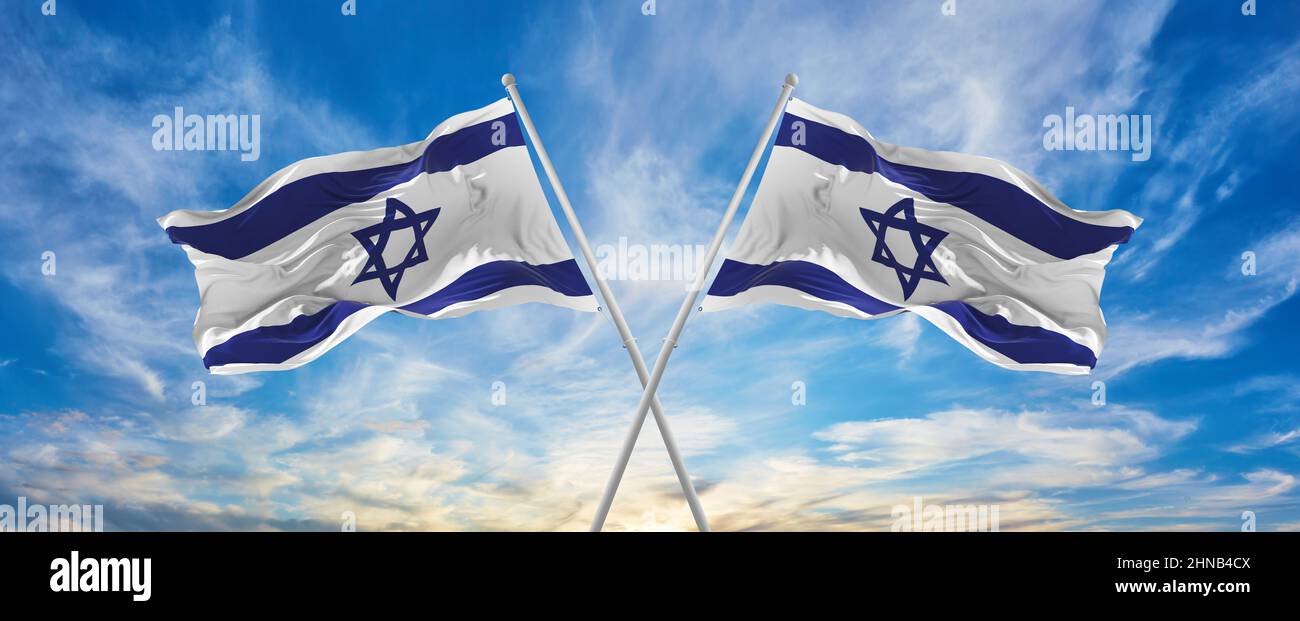 two crossed national flags of Israel waving in the wind at cloudy sky ...
