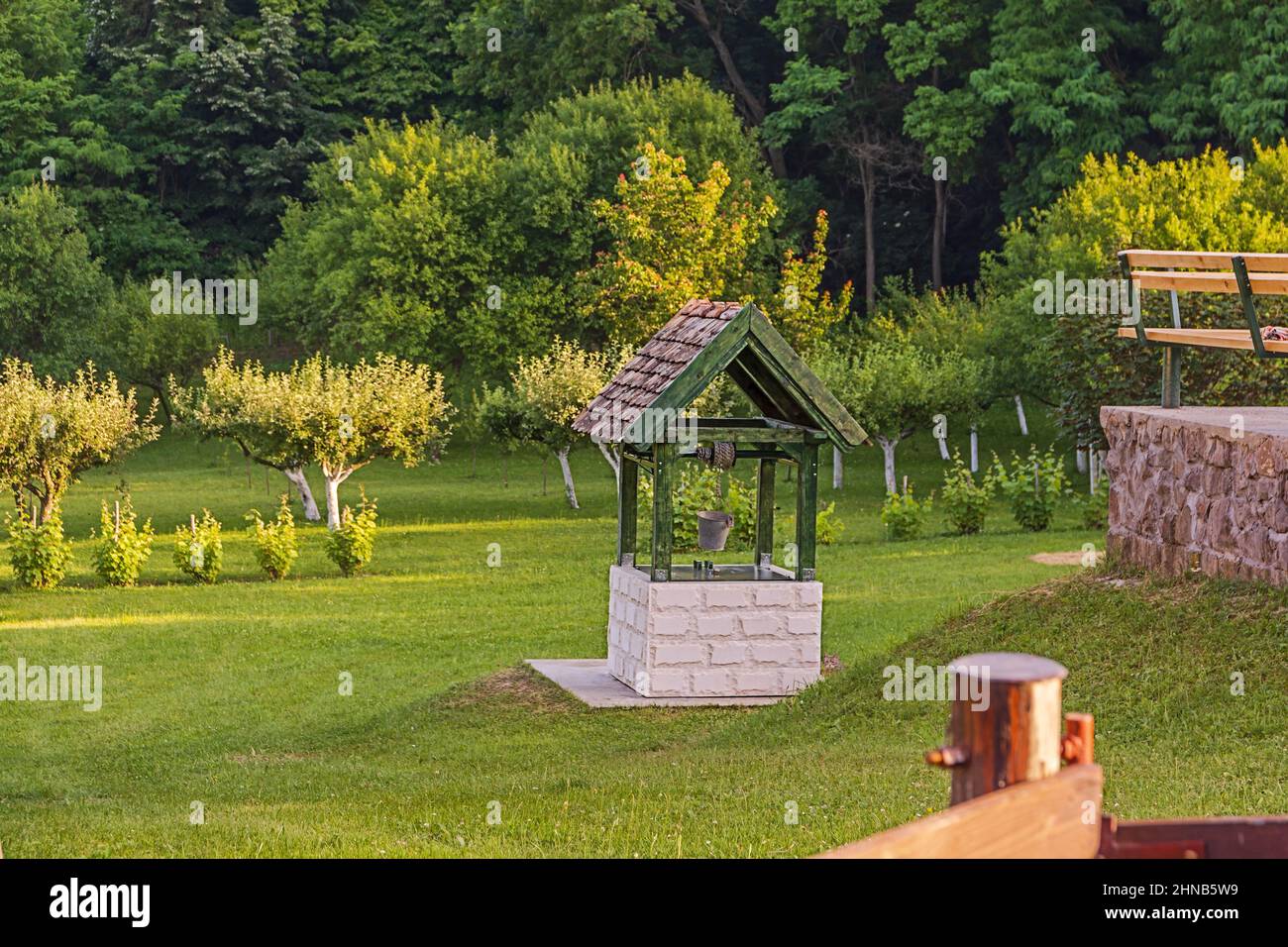 Water stone well on country with green grass and forest Stock Photo - Alamy