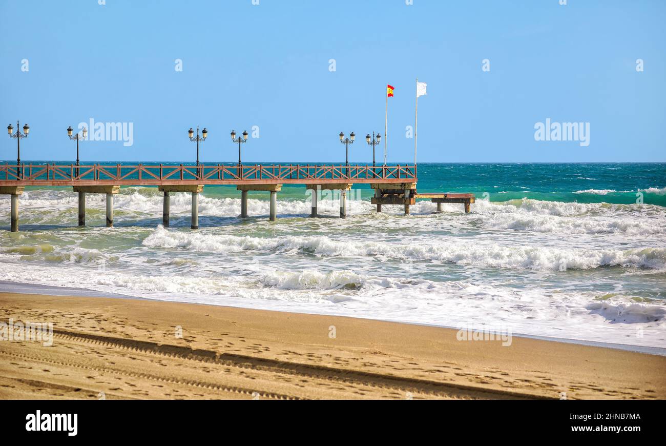 Sandy beach and wooden pier on the Costa del Sol in Marbella, Spain ...