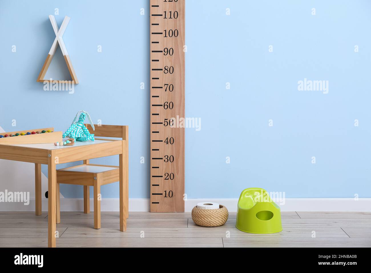 Wooden table with chair, ruler, toilet paper roll and green potty near ...