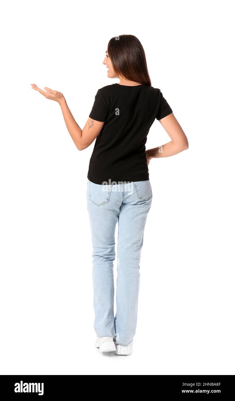 Young woman in blank t-shirt showing something on white background ...