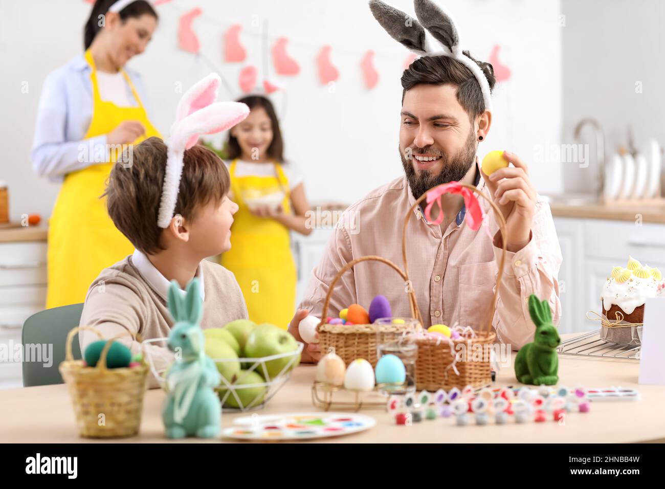Happy father with his little son and Easter eggs in kitchen Stock Photo ...