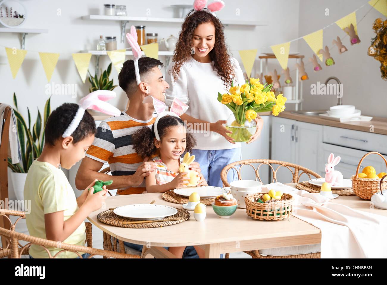 Happy family at dining table in kitchen on Easter day Stock Photo - Alamy