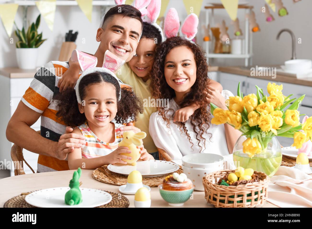 Happy family celebrating Easter at dining table in kitchen Stock Photo ...