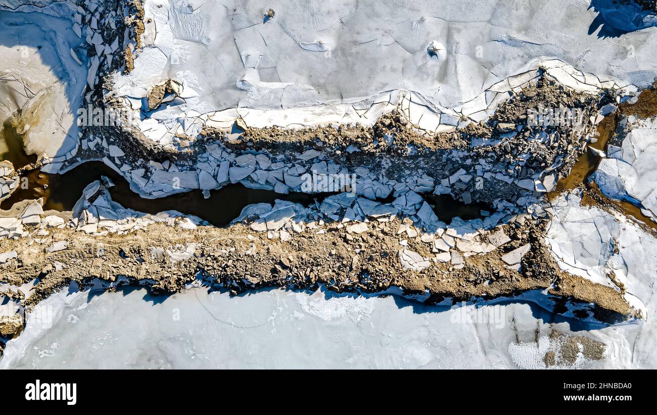 The ice has broken as snow melts at the quarry forming a small stream ...