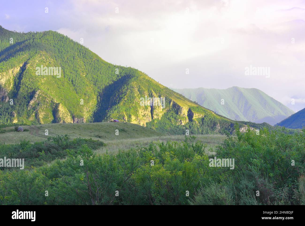Rocks covered with grass under a cloudy sky. Siberia, Russia Stock ...