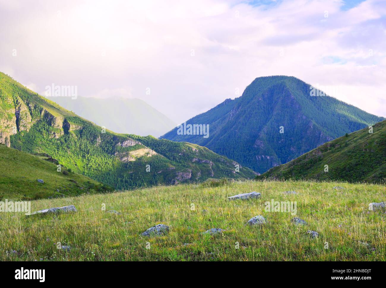 Rocks covered with grass under a cloudy sky. Siberia, Russia Stock ...