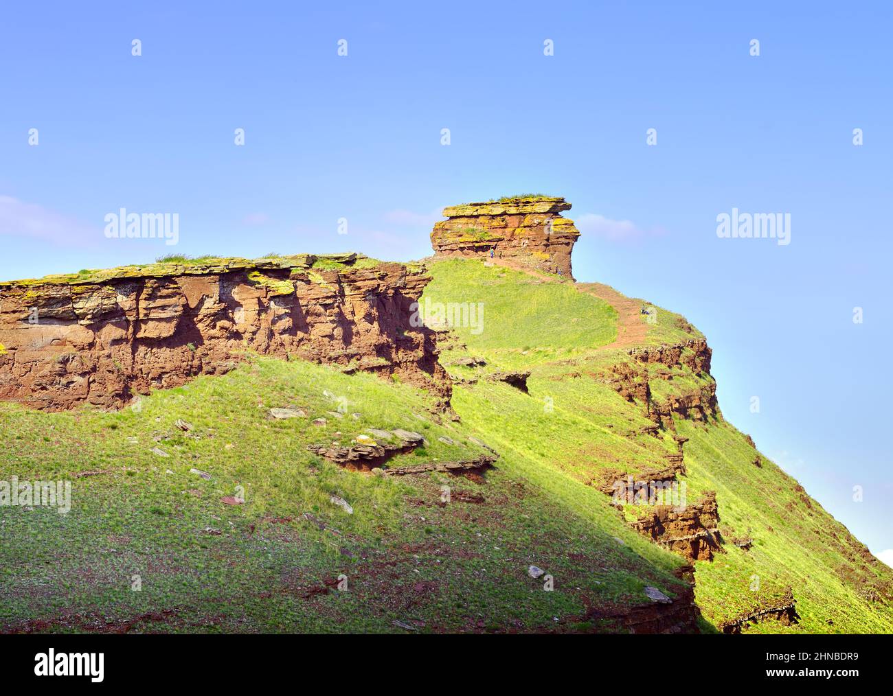 The tops of red rock cliffs in summer under a blue sky. Siberia, Russia ...