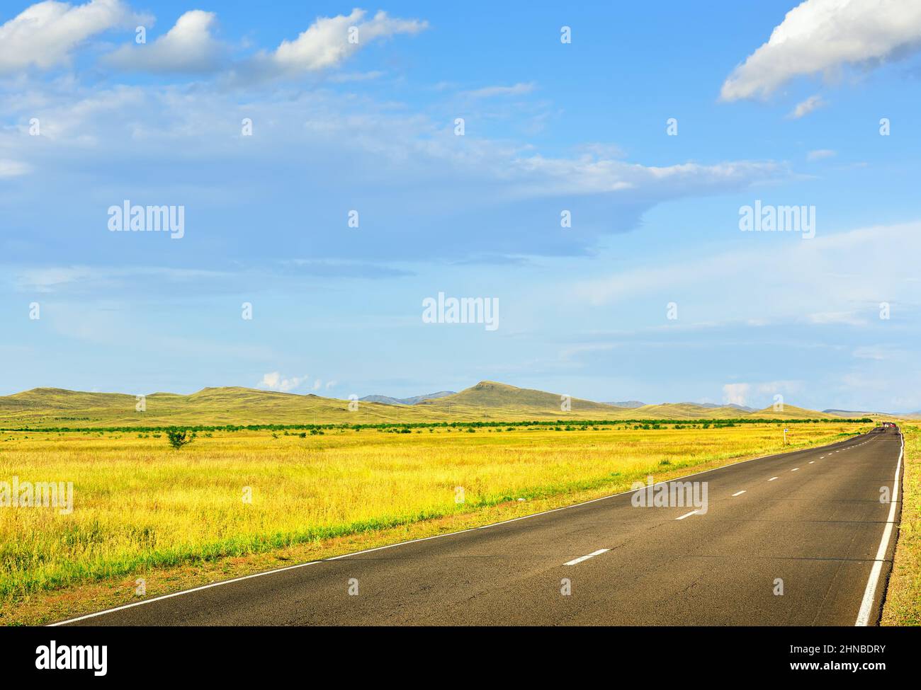 Yellow grass at the foot of the conical hills in summer under a blue ...