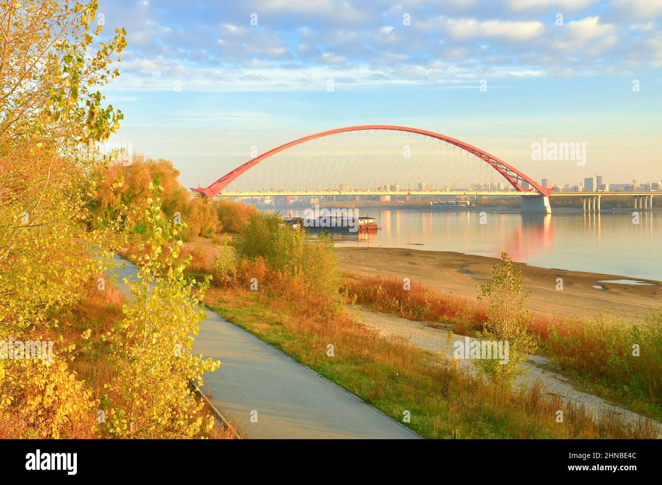 The bank of the Ob River. Arched Bugrinsky bridge on the sandy banks of ...