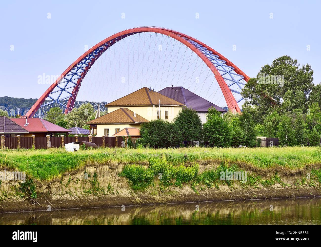 Cottages on the bank of the river Ini on the background of the arch of ...
