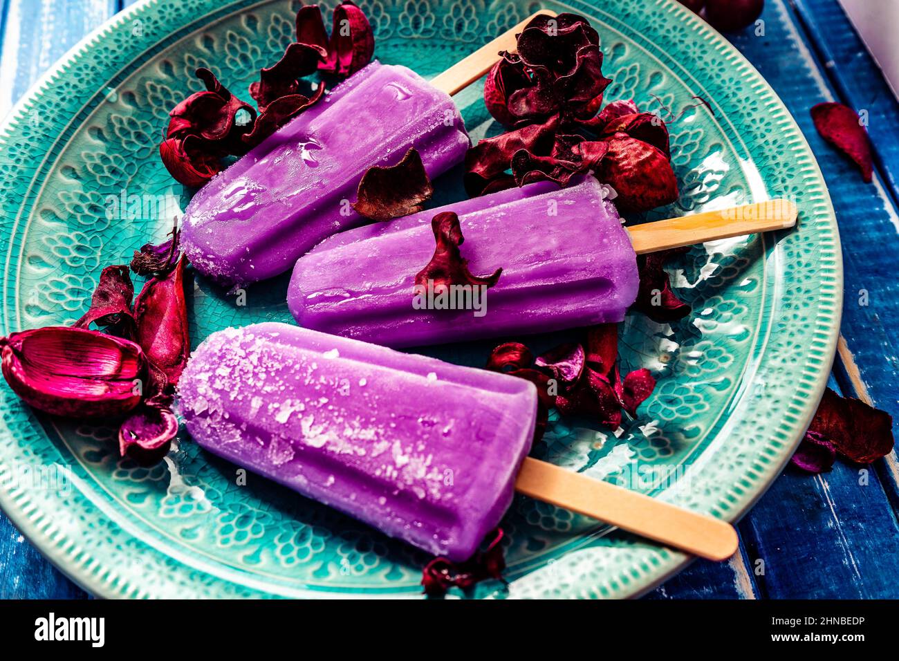 A Lollipop style grape ice cream on a stick on a vintage plate on a ...
