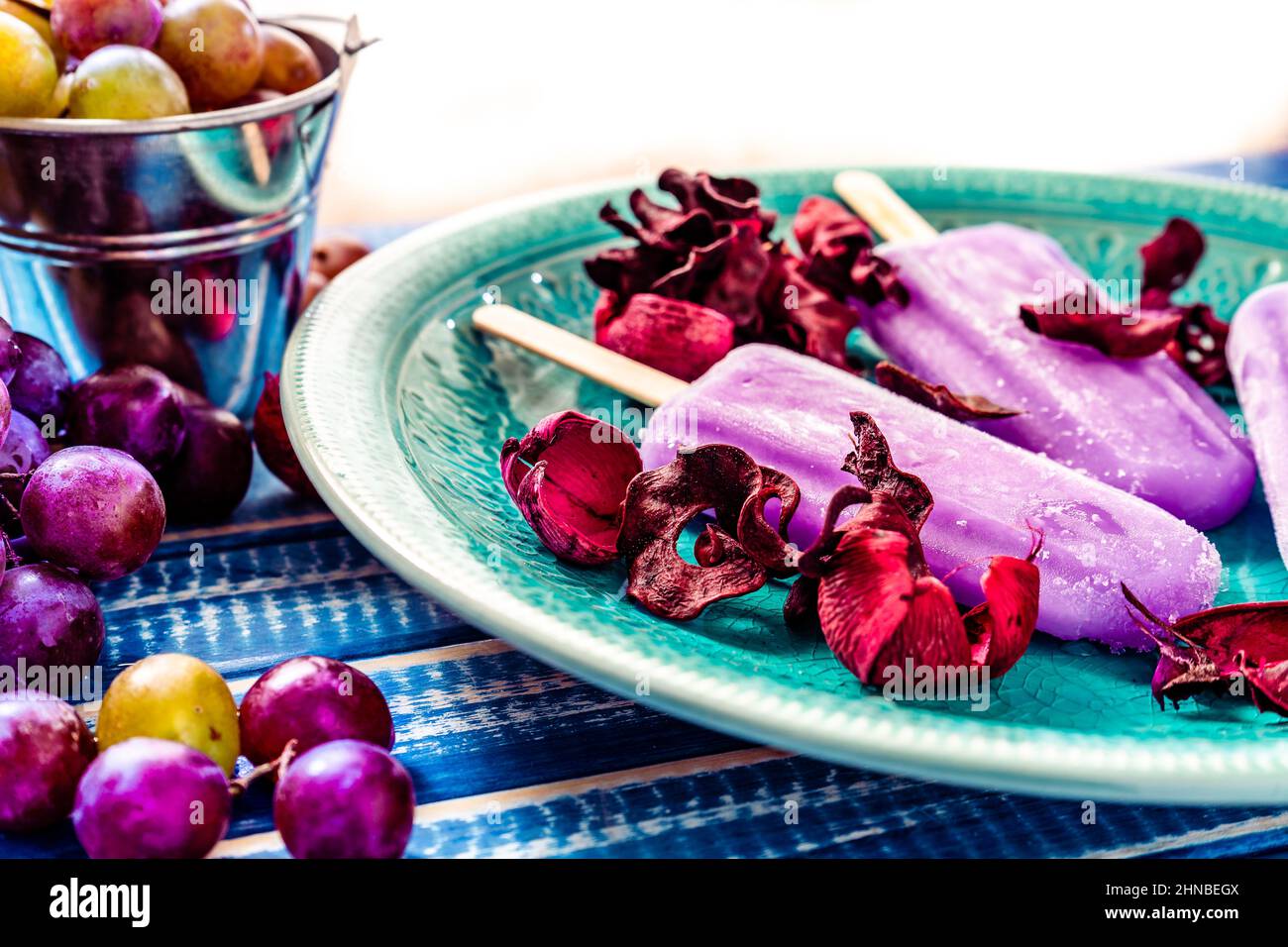 A Lollipop style grape ice cream on a stick on a vintage plate on a ...