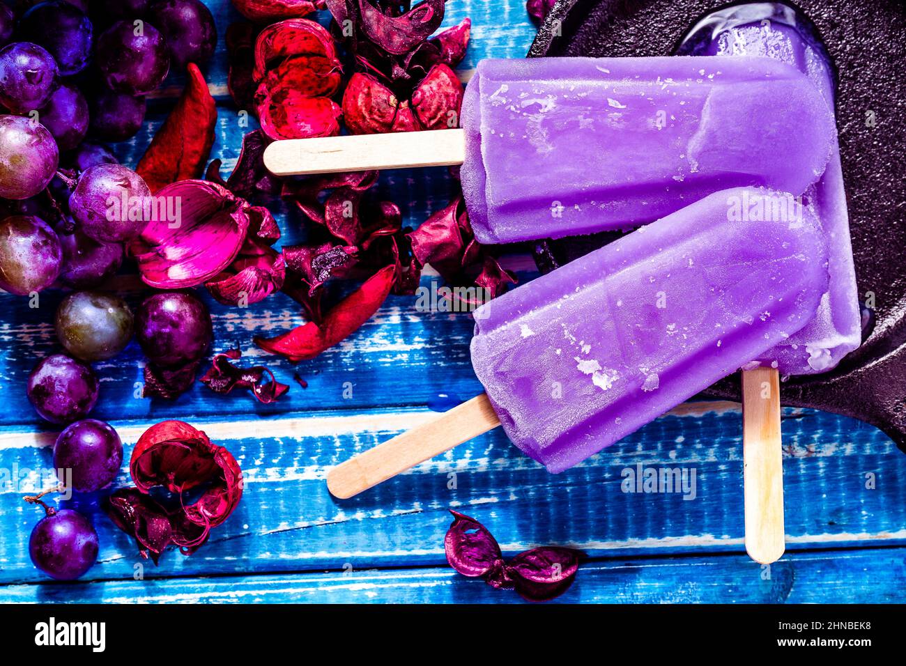 Three lollipop-style grape ice cream on a stick on a cast iron platter ...