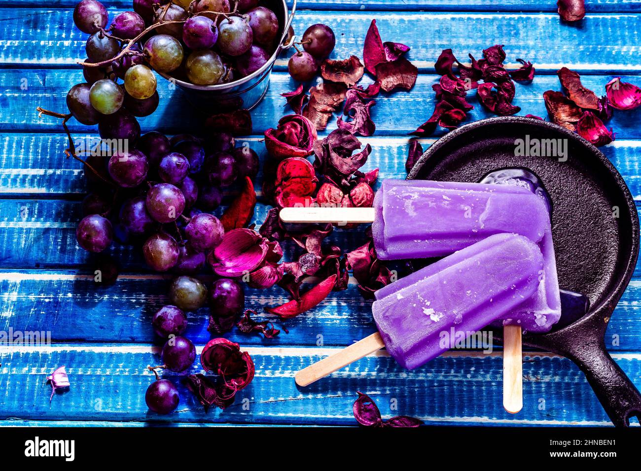 Three lollipop-style grape ice cream on a stick on a cast iron platter ...
