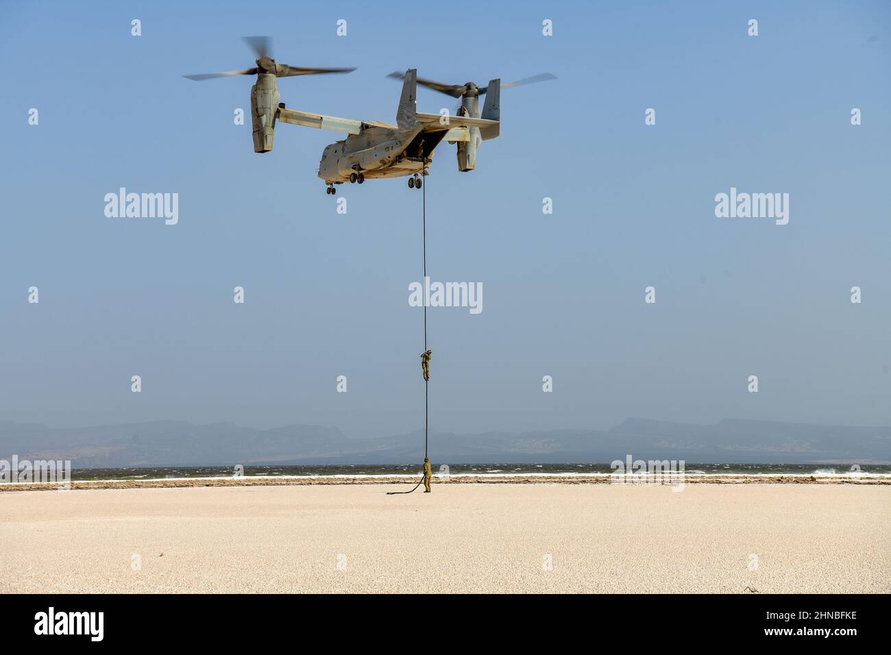 An 82nd Expeditionary Rescue Squadron pararescueman fast ropes out of ...