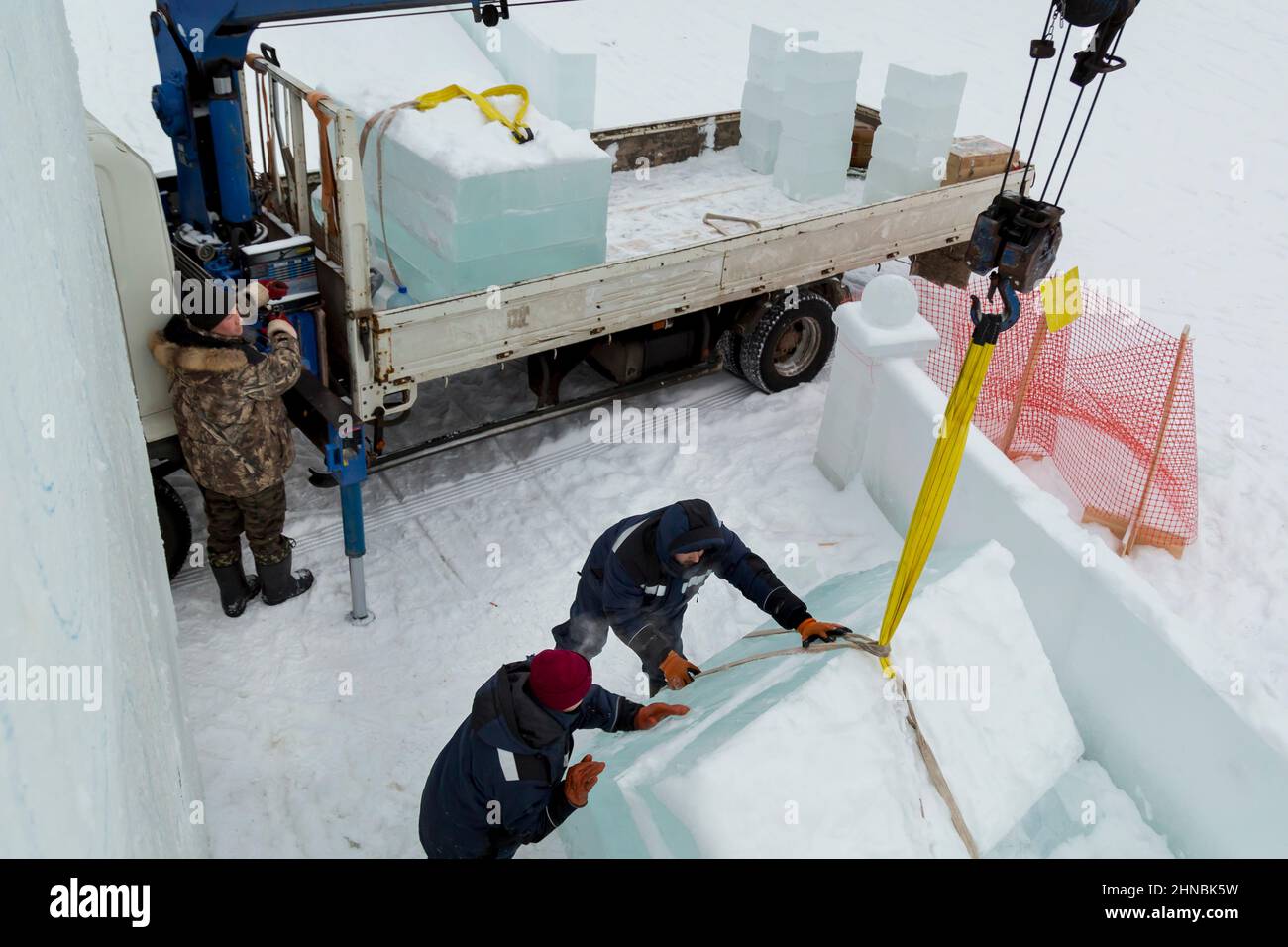 Slingers unload ice slabs with a truck crane Stock Photo - Alamy