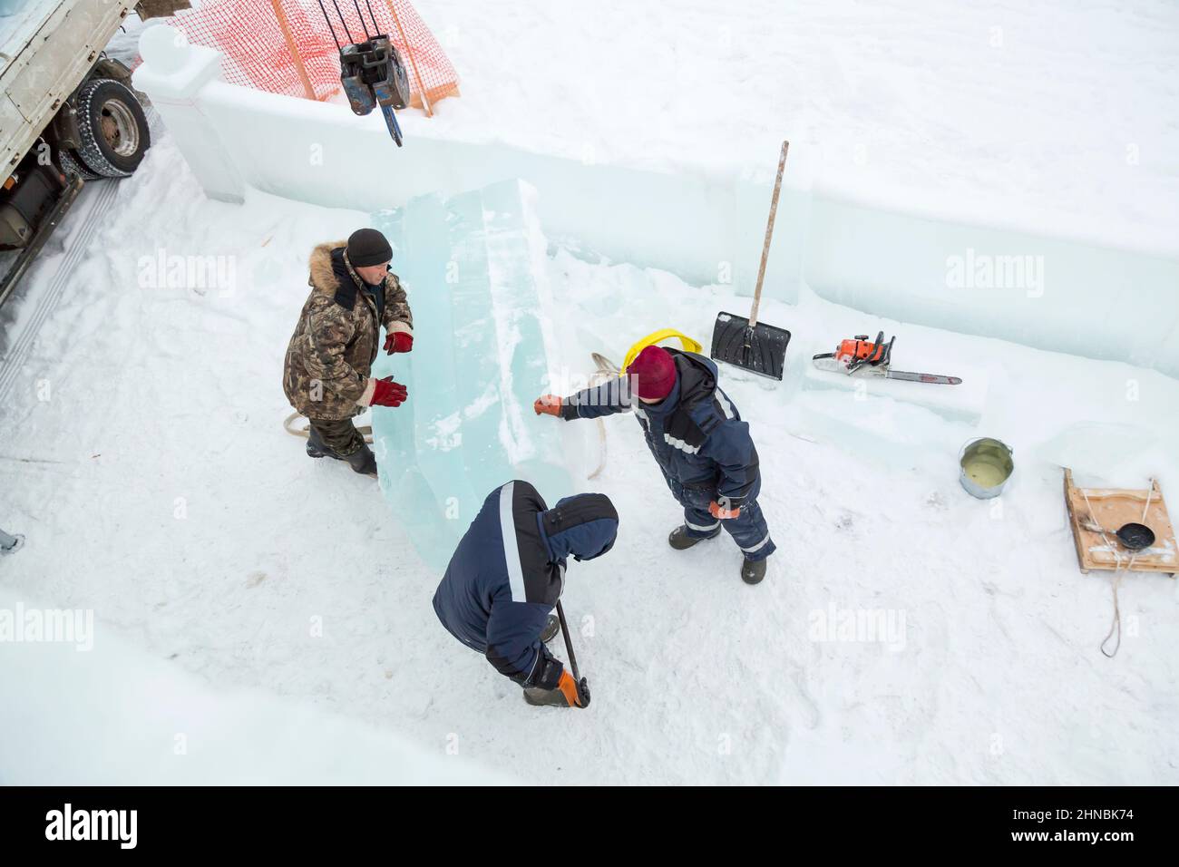 Slingers unload ice slabs with a truck crane Stock Photo - Alamy
