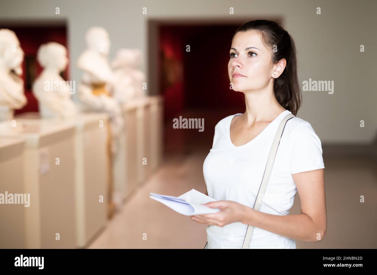 Woman observing sculptures exposition in art museum Stock Photo - Alamy