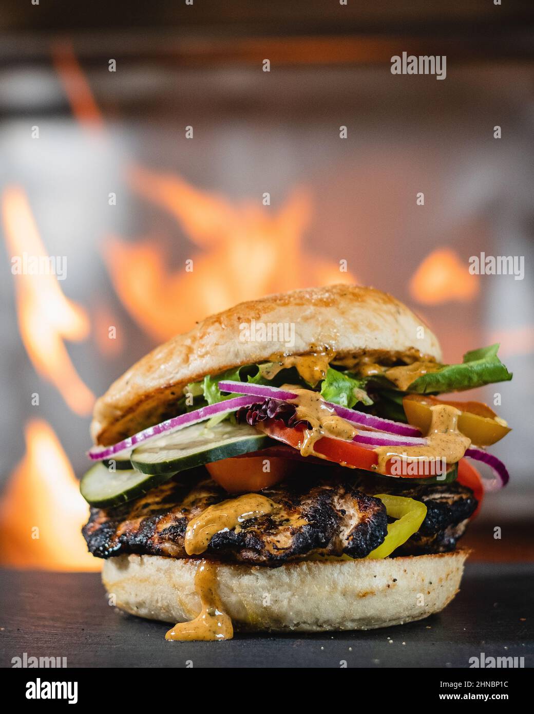 Vertical shot of a fresh delicious chicken burger with vegetables and ...