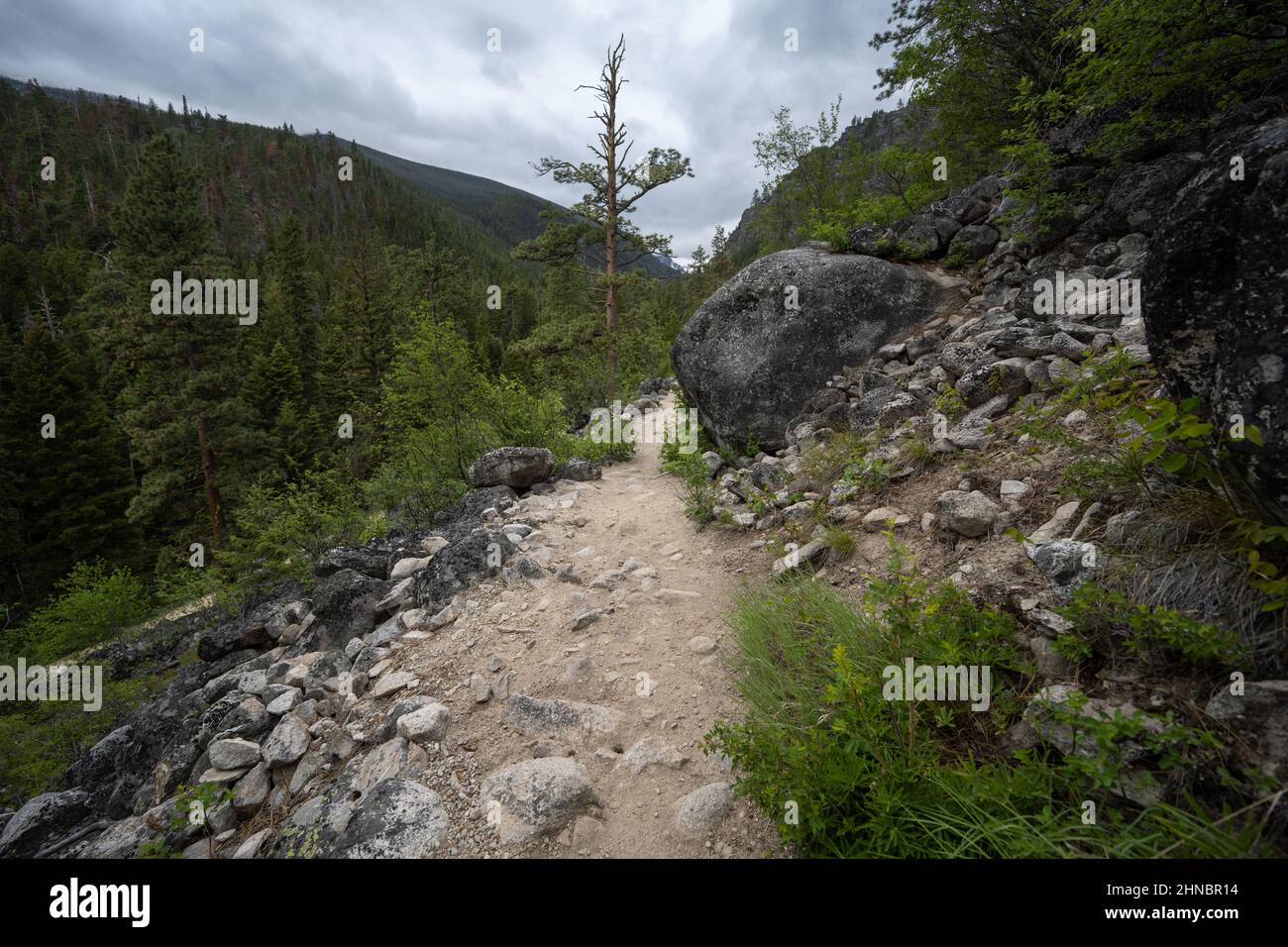 Hiking trail on a ledge with large boulders Stock Photo - Alamy