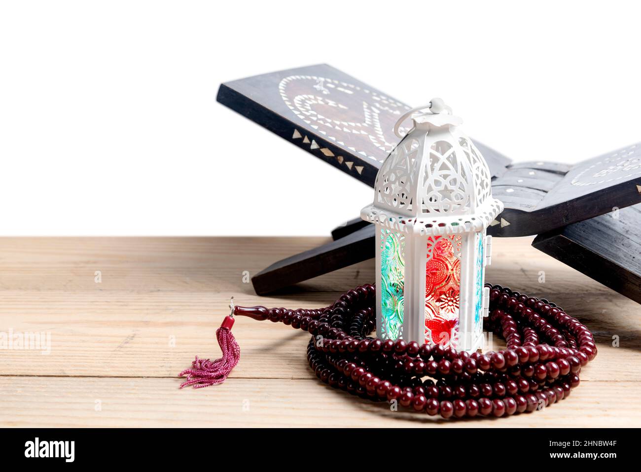 Arabic lamp with colorful light and prayer beads on wooden table with ...