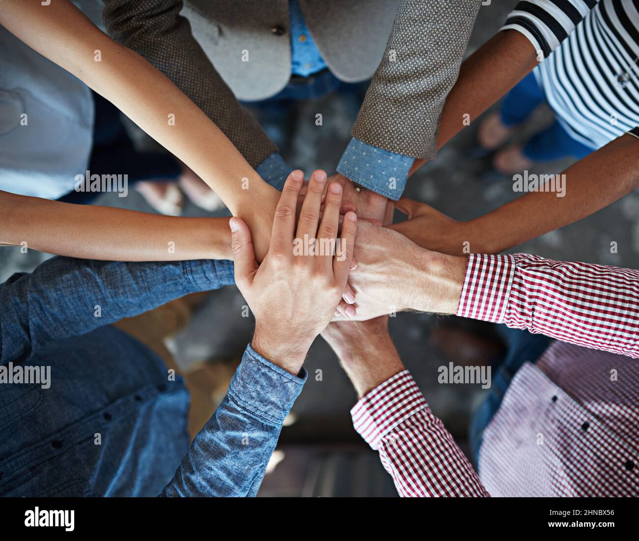 We say yes to team success. Top view of co-workers hand put together in ...