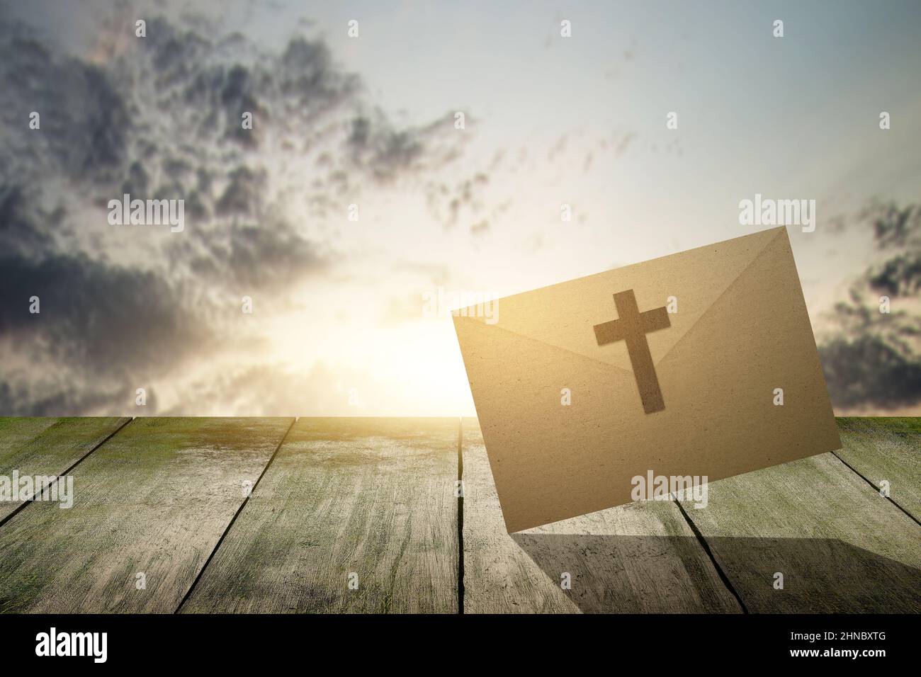 Envelope with Christian cross on wooden table with a dramatic sky ...