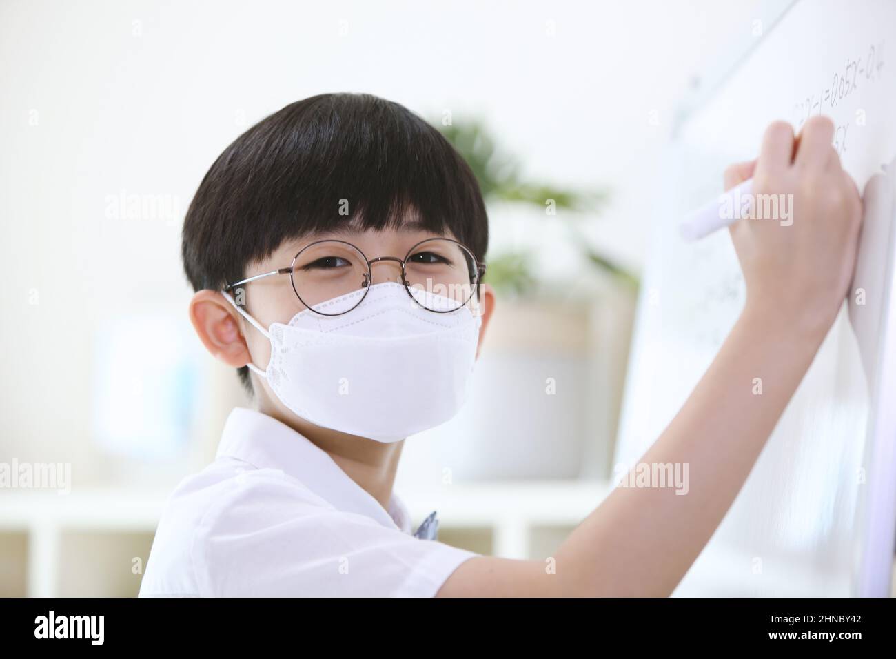 A cute and smart boy wearing a mask at school or academy for epidemic ...