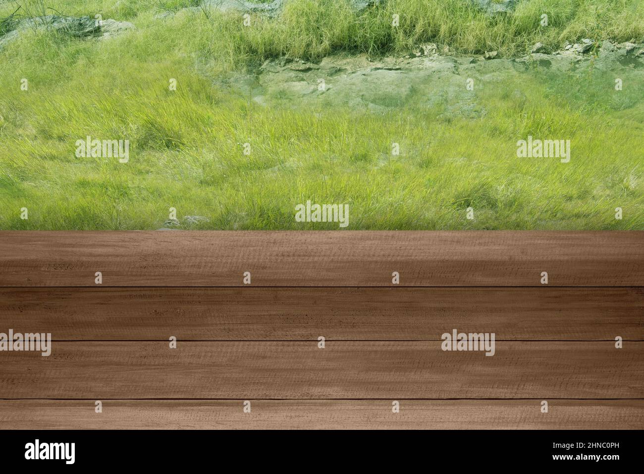 Wooden table with green grass field background Stock Photo - Alamy