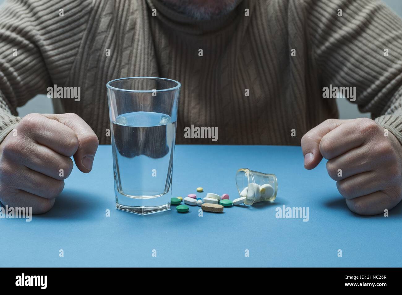 The man clenches his hands into fists, medical preparations and a glass ...