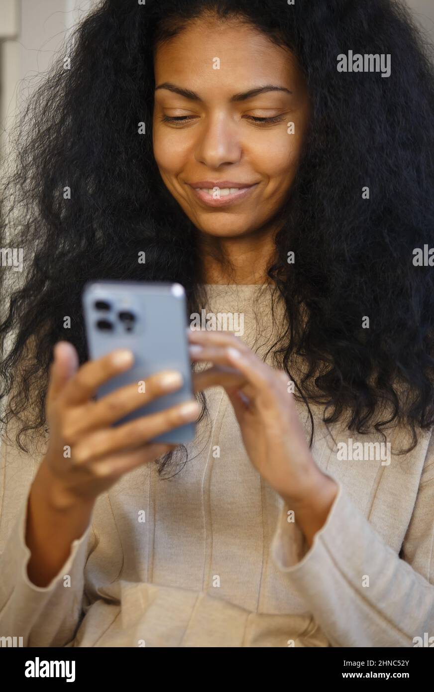 Happy black woman browsing internet on mobile phone. Cheerful African ...