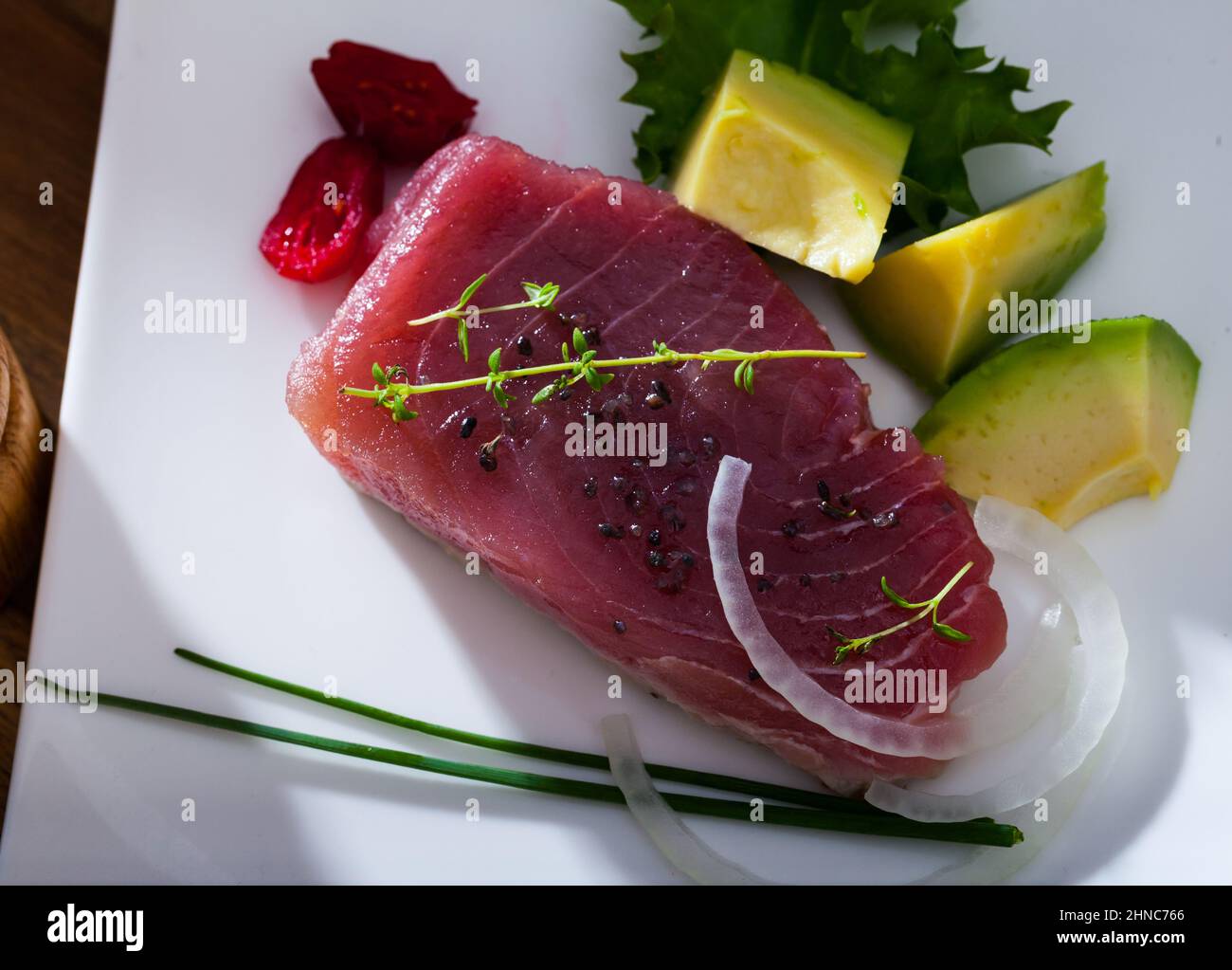 Delicious pieces raw tuna, green avocado and greens at plate Stock ...