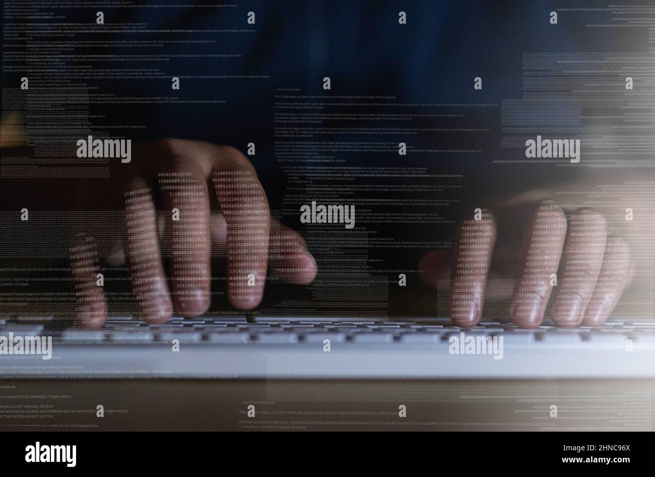 Tapping in to another network. Shot of an unrecognisable hacker using a computer in the dark ...