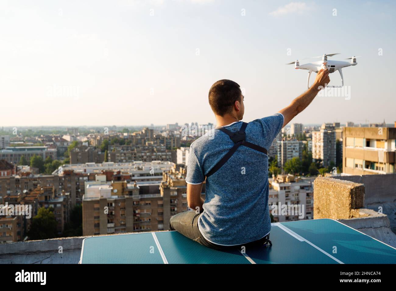 Young technician flying UAV drone with remote control on rooftop Stock ...