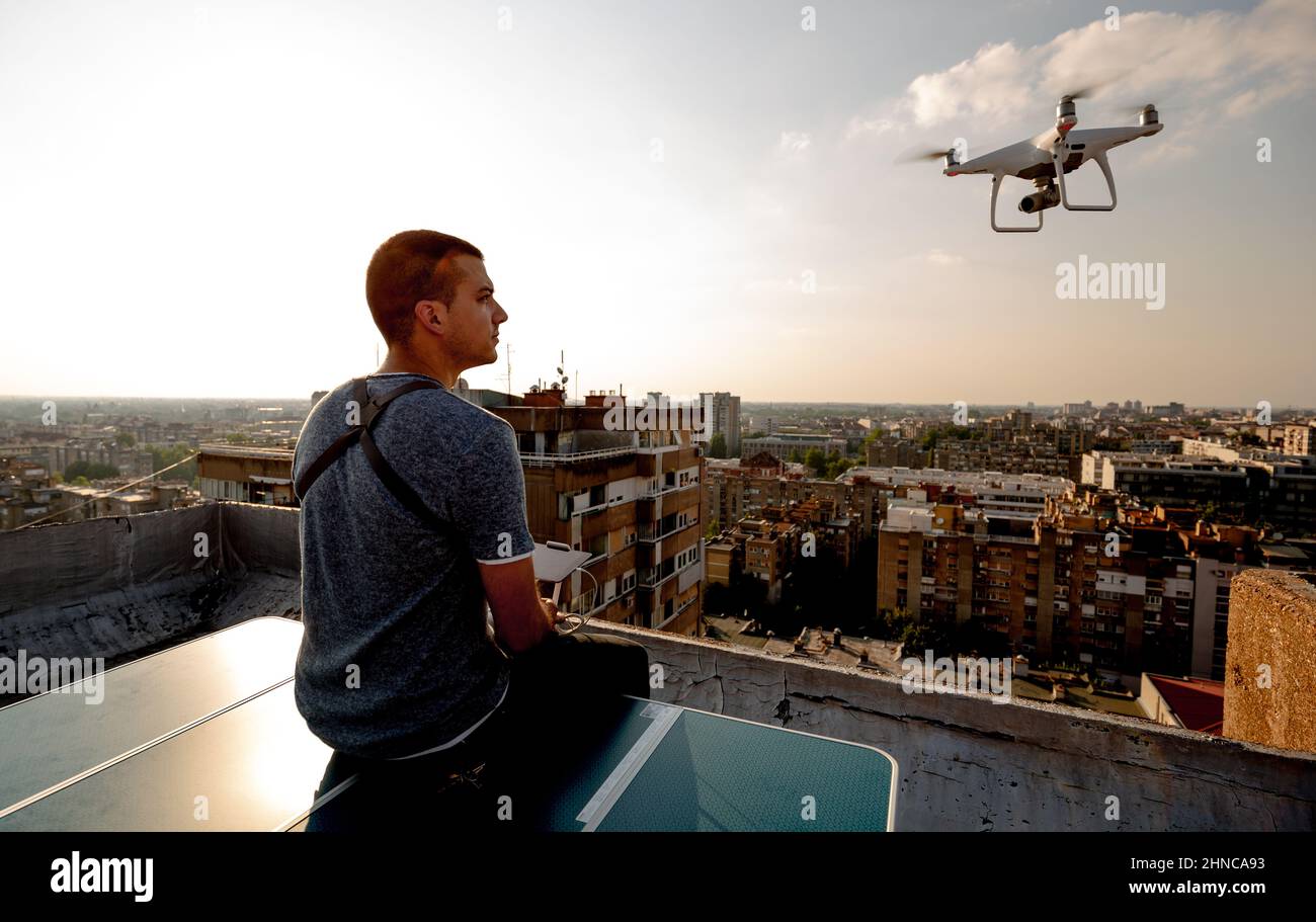 Young technician flying UAV drone with remote control on rooftop Stock ...