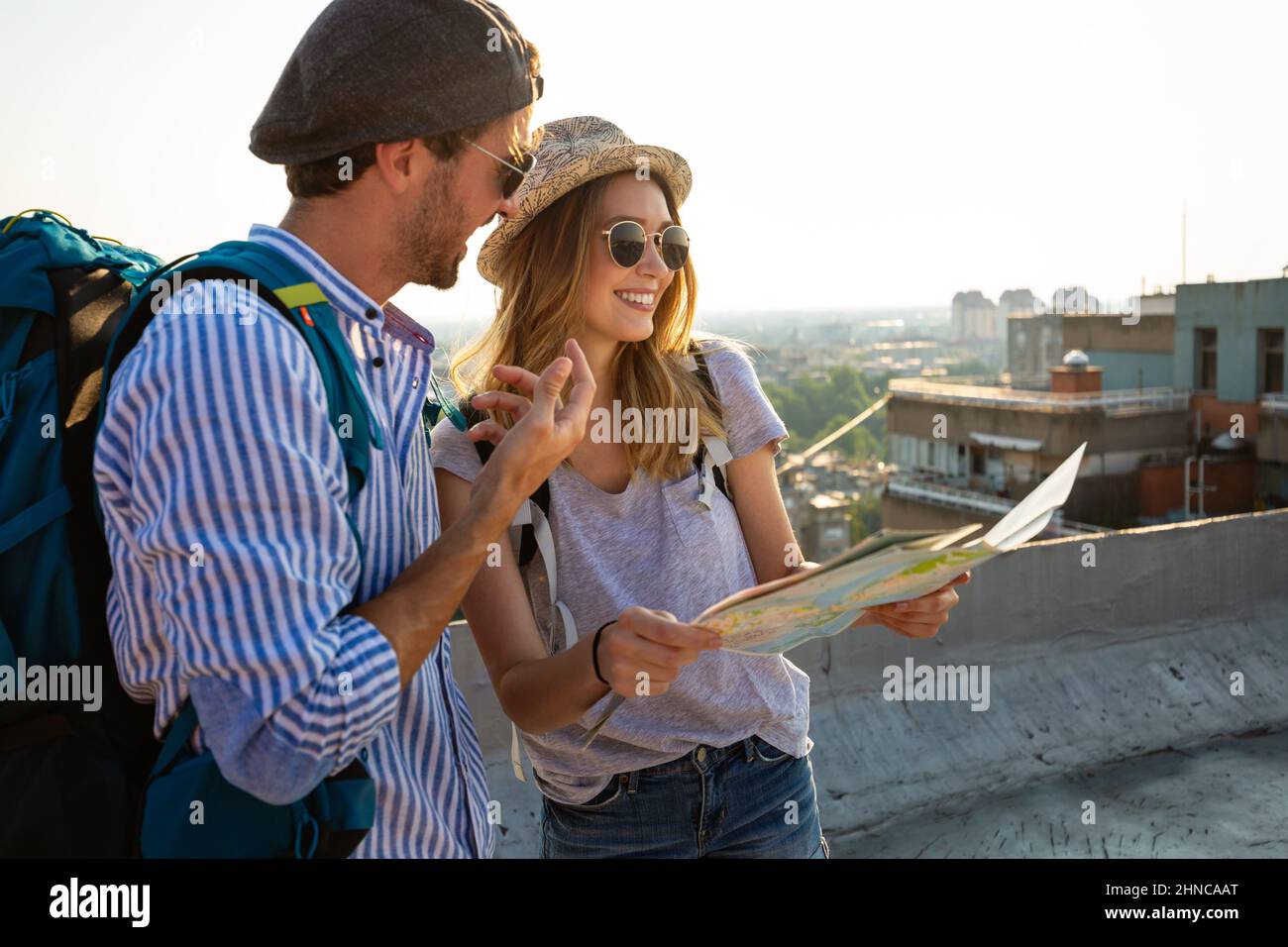 Happy tourist couple, friends sightseeing city with map. Travel people ...