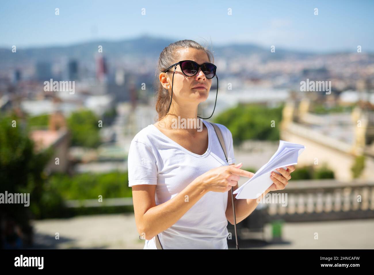 Young woman with paper guide observing sightseeings Stock Photo - Alamy