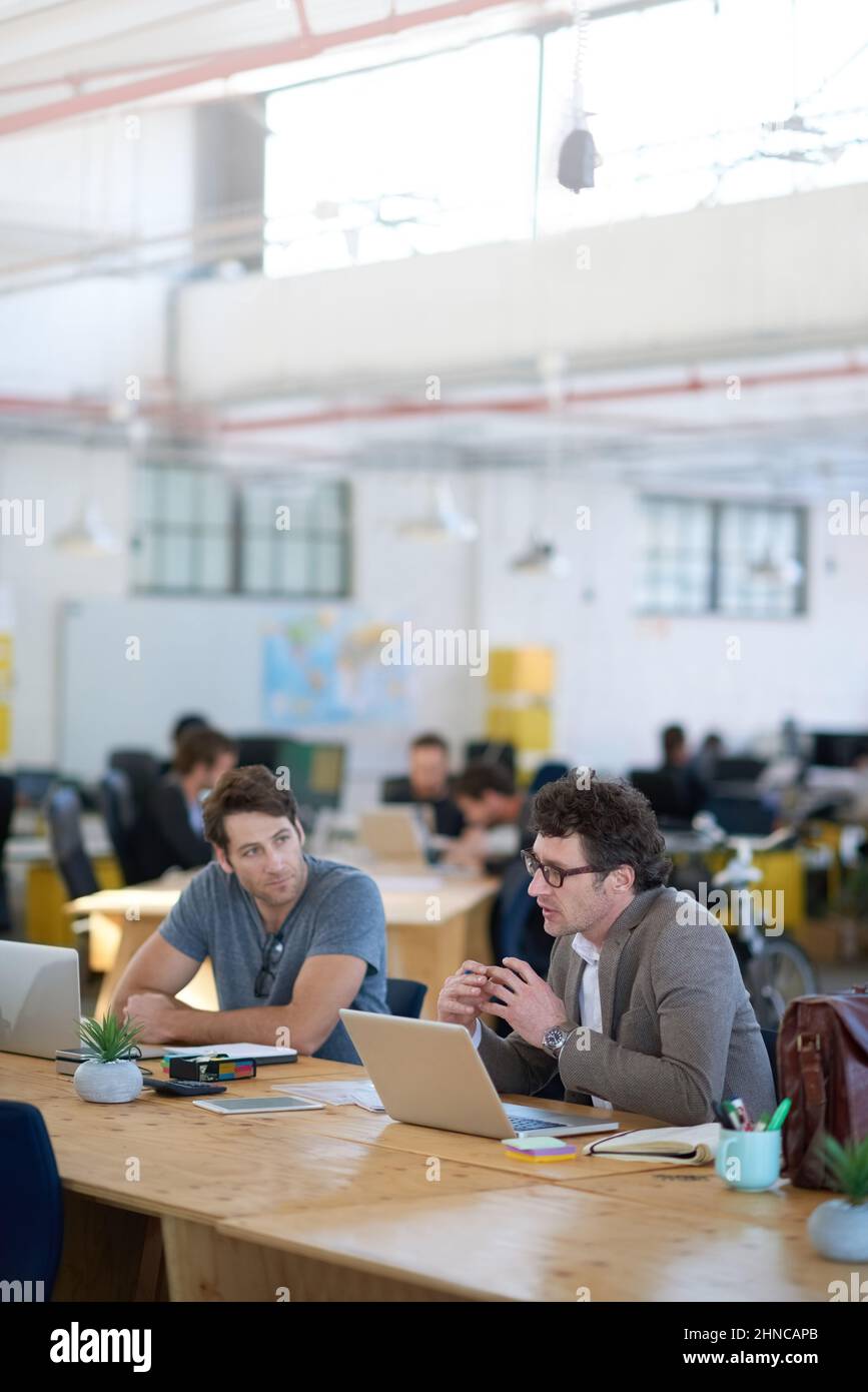 Talking through their creative process. Shot of two colleagues talking ...