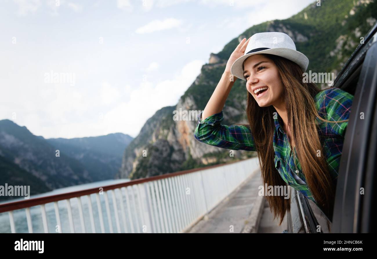 Woman in car road trip waving out the window smiling Stock Photo - Alamy
