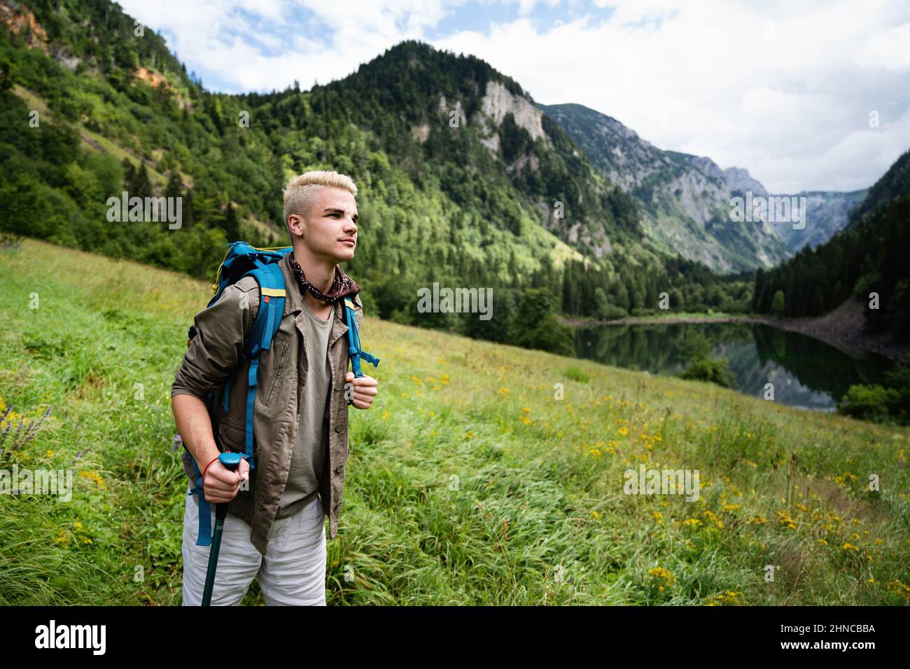 Adventure man hiking wilderness mountain with backpack Stock Photo - Alamy
