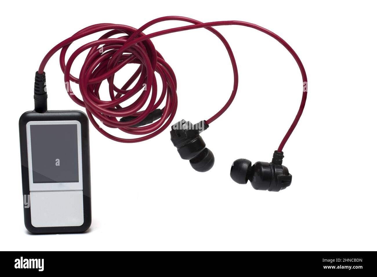 Close up of silver black music player with red cable headphones on it ...