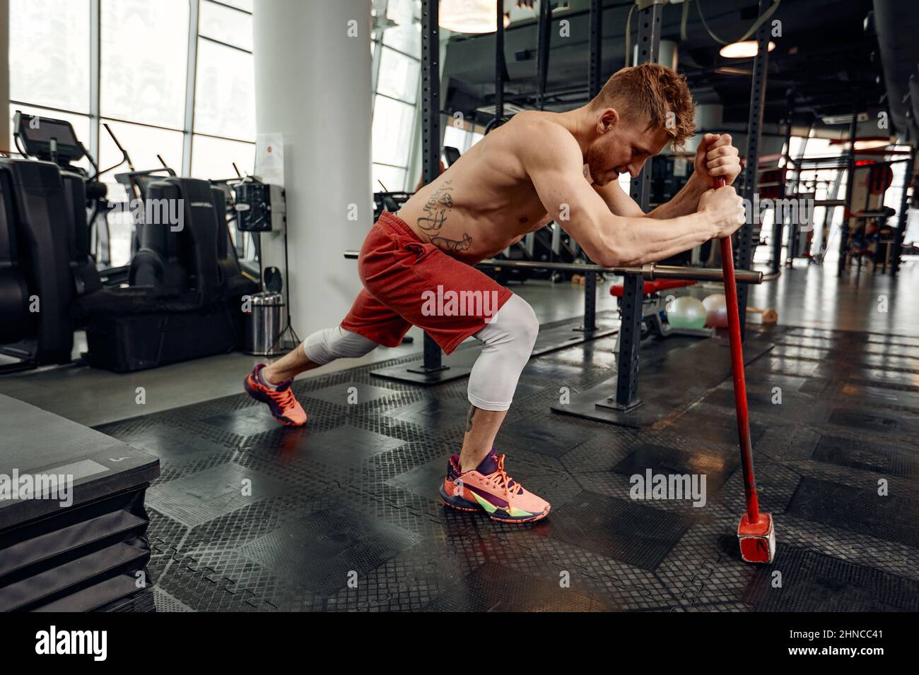 Man fitness training with large and heavy tire hits hammer. Concept ...