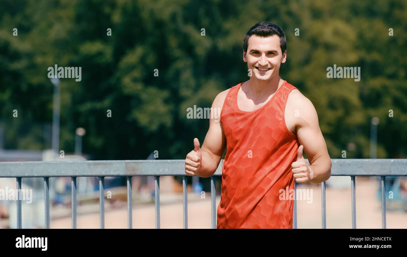 happy sportsman showing thumbs up on bridge Stock Photo - Alamy