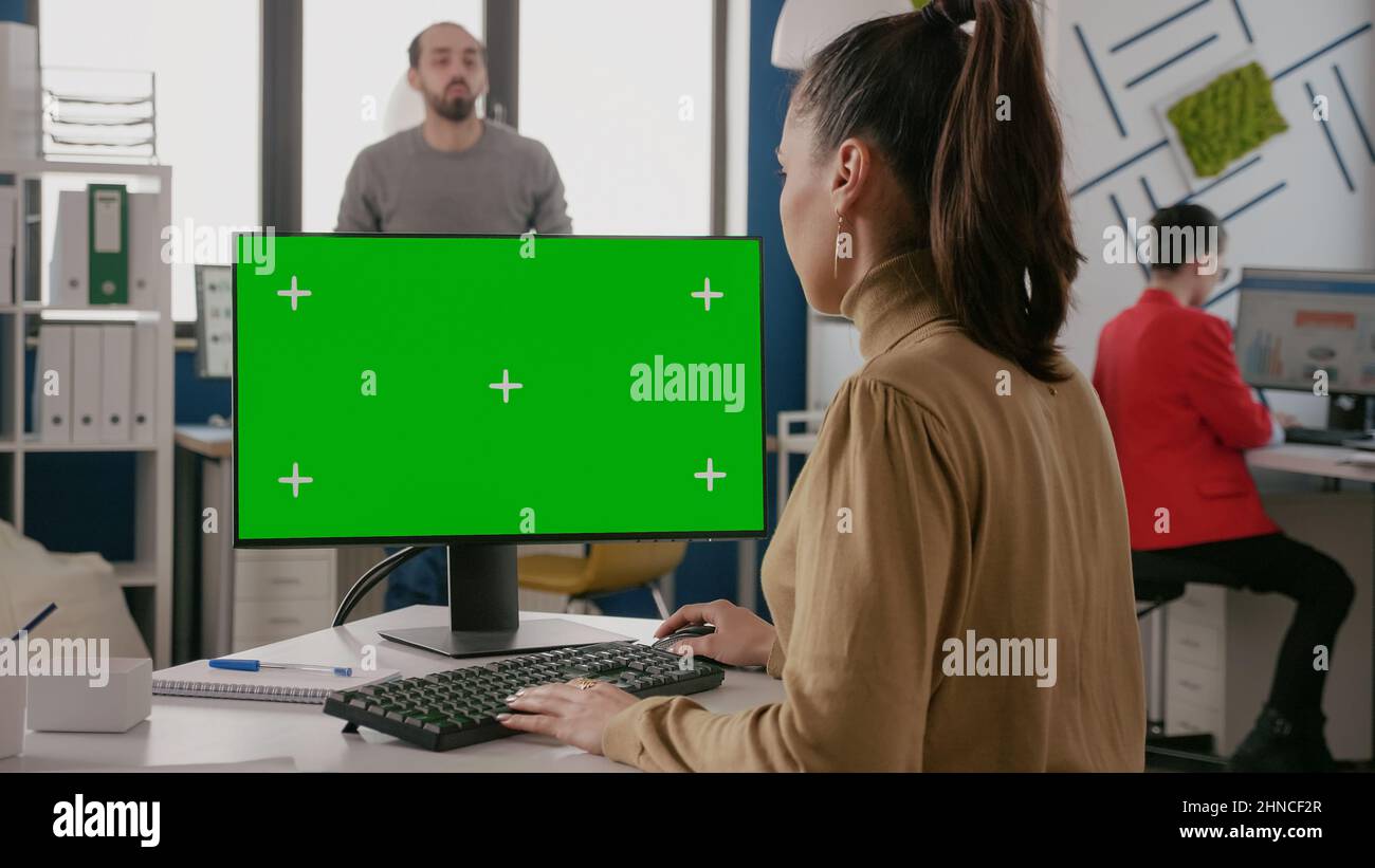 Business woman using monitor with green screen in startup office ...