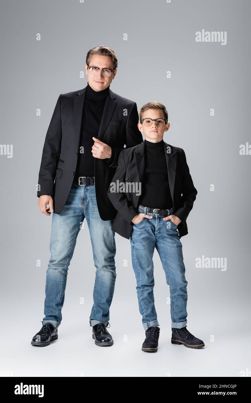 Full length of stylish father and son posing on grey background Stock ...