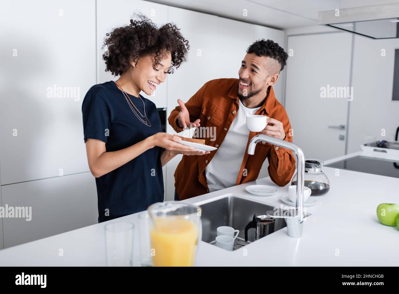 happy african american man pointing at sandwich near girlfriend in ...